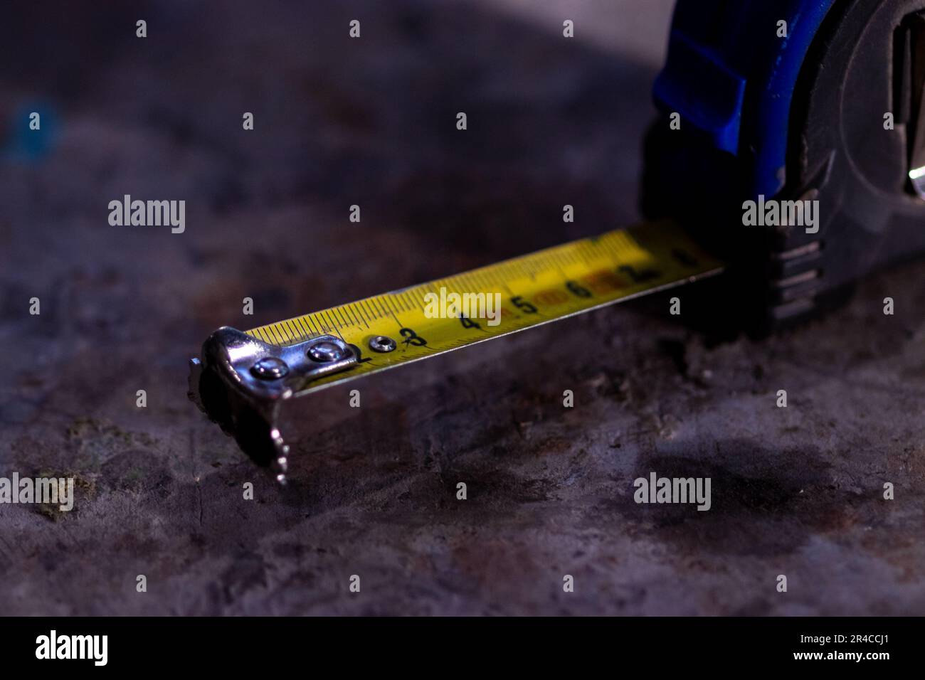 A measuring ruler rests on a dusty floor illuminated by a light source ...