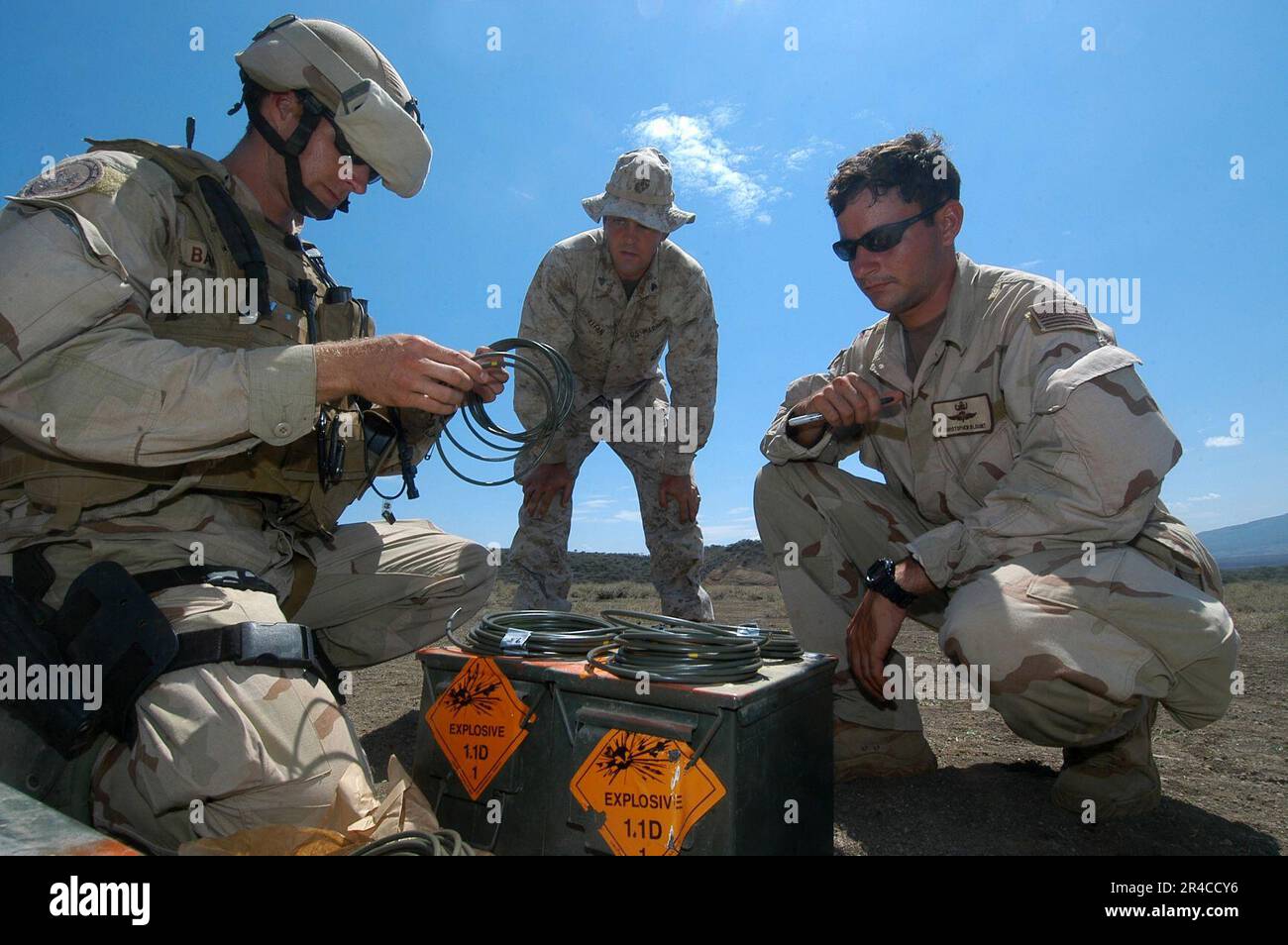 US Navy U.S. Marine Cpl. center, watches U.S. Navy Explosives Ordnance ...