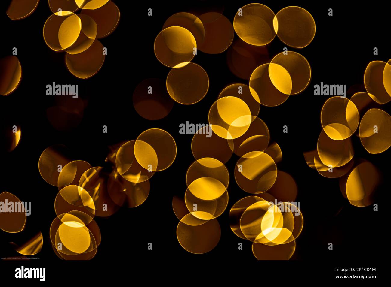 This image features an abstract array of yellow circles illuminated ...