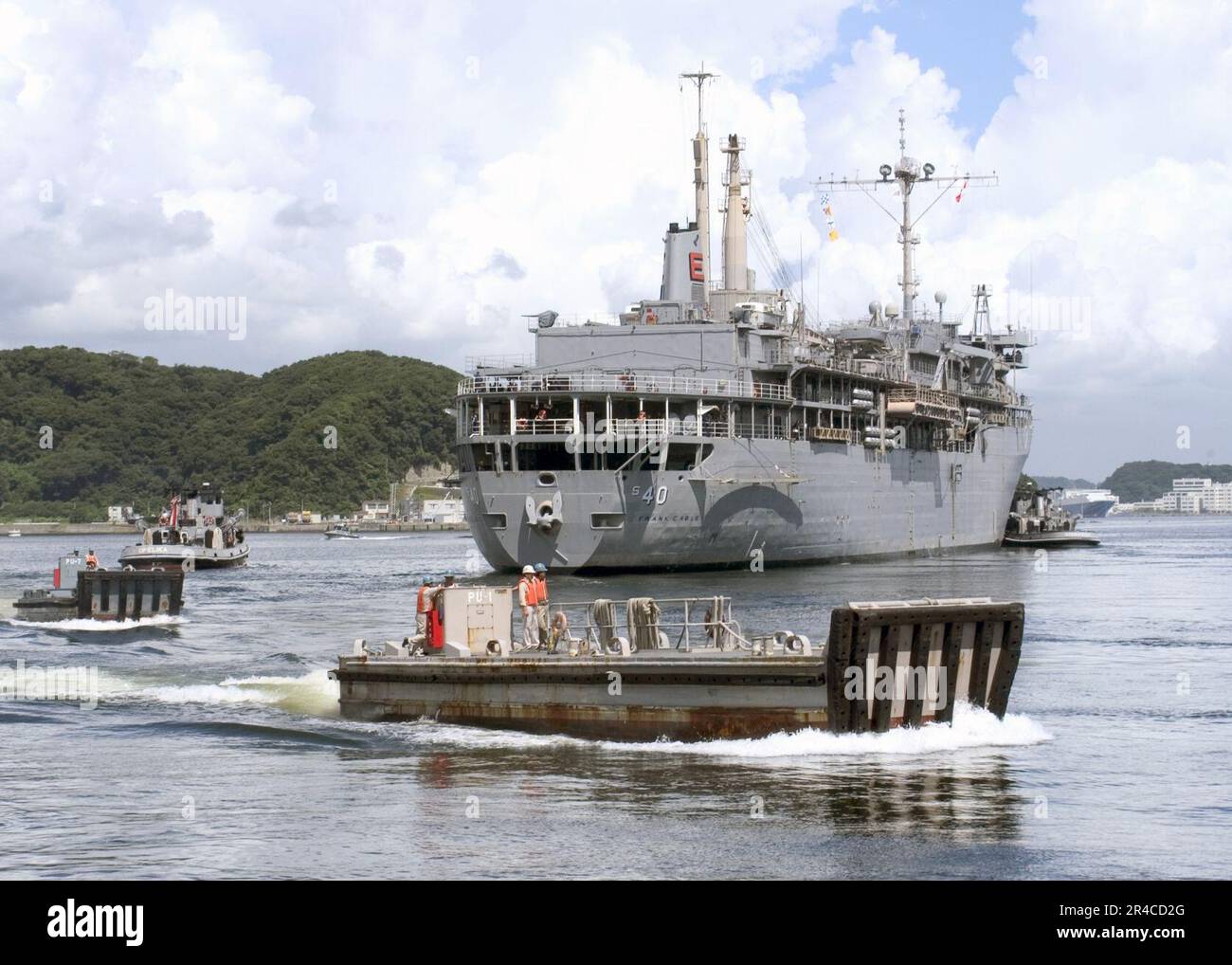 US Navy Pusher boats pull back into port as tugboats escort the ...