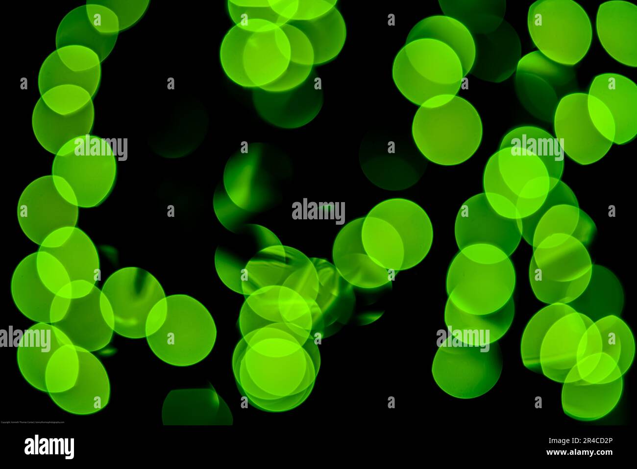 A vibrant green light glows brightly against a dark background ...