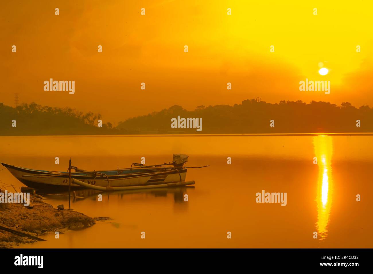 Traditional boat moored on the calm and tranquil lake during sunrise in ...
