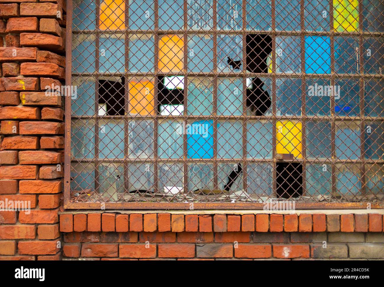 A vibrant wall is visible behind a window in a brick building located ...