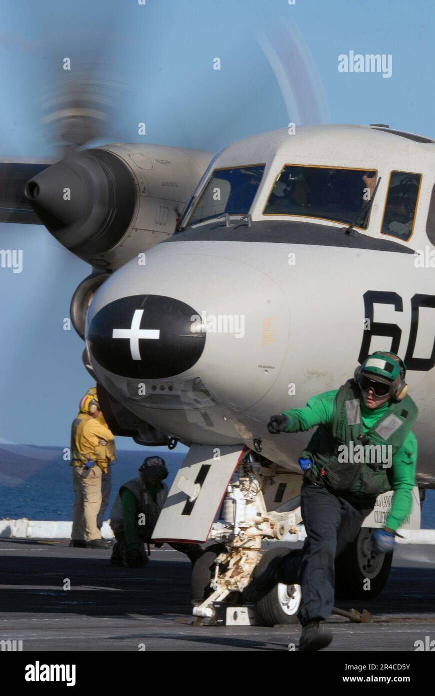 US Navy A holdback bar operator sprints from the front of an E-2C ...