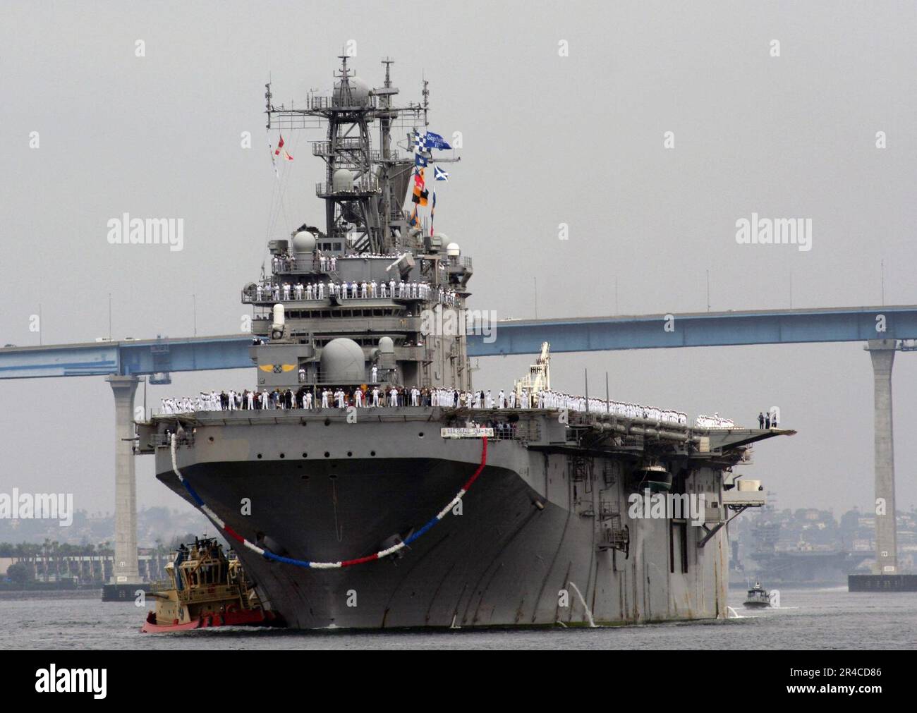 US Navy Sailors man the rails aboard the amphibious assault ship USS Peleliu (LHA 5), as the ...
