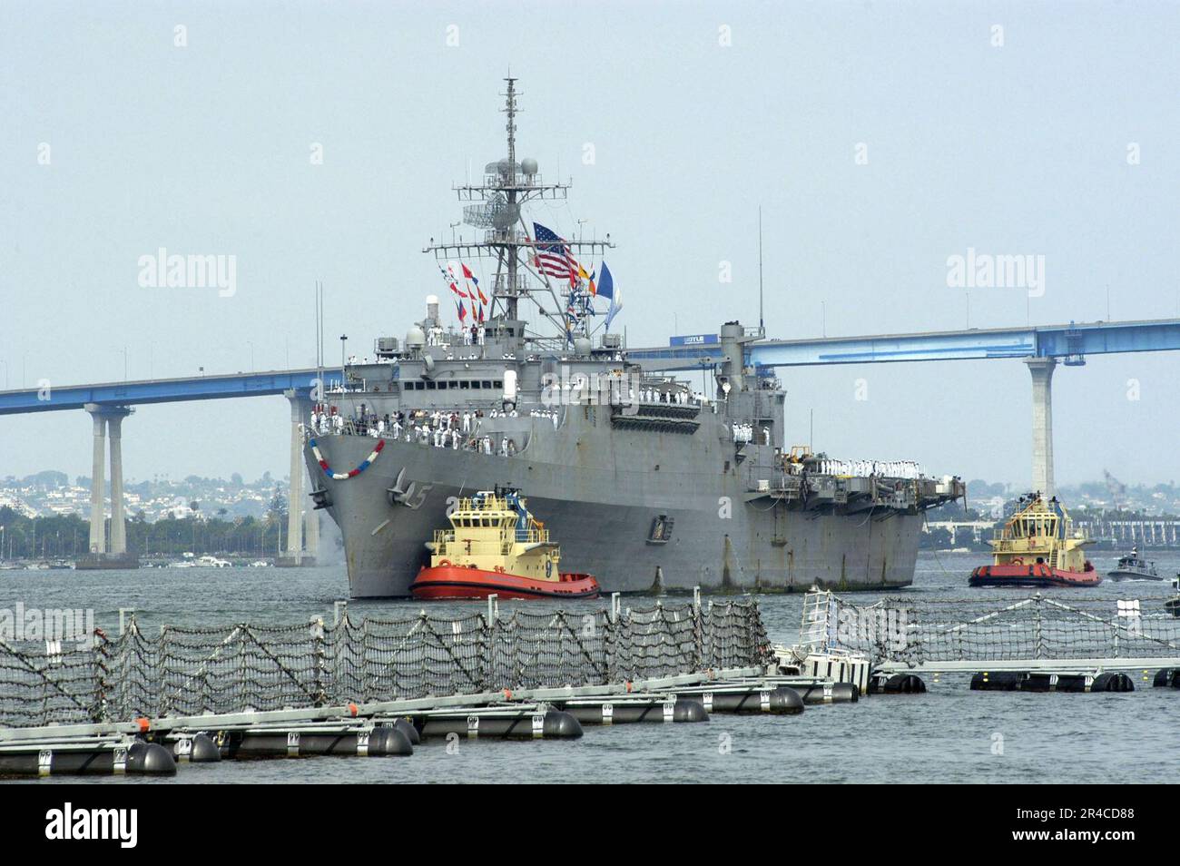 US Navy Tugboats guide the transport dock ship USS Ogden (LPD 5) into ...