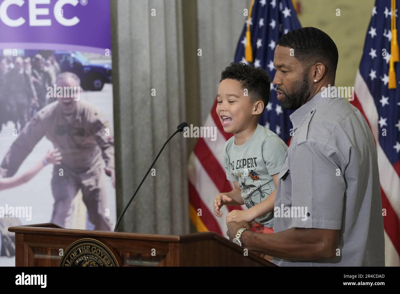 A child gleefully tests the mic prior to a Month of the Military Child ...