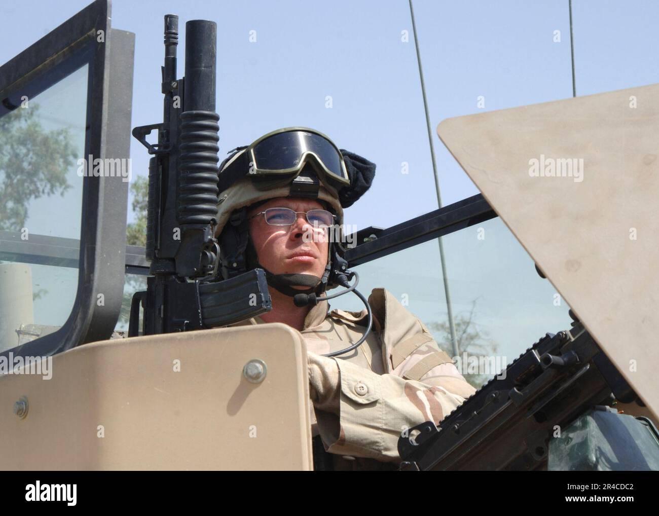 US Navy Gunner's Mate 1st Class mans the gun turret of a humvee while ...
