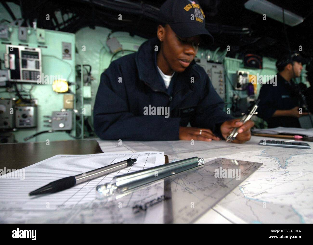 US Navy Quartermaster 3rd Class charts the ship's position in the pilot ...