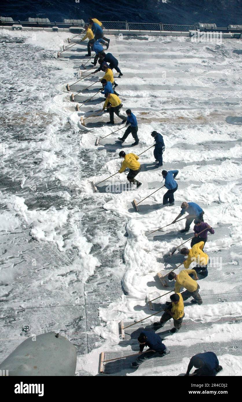 US Navy Sailors conduct a scrubbing exercise on the flight deck aboard ...