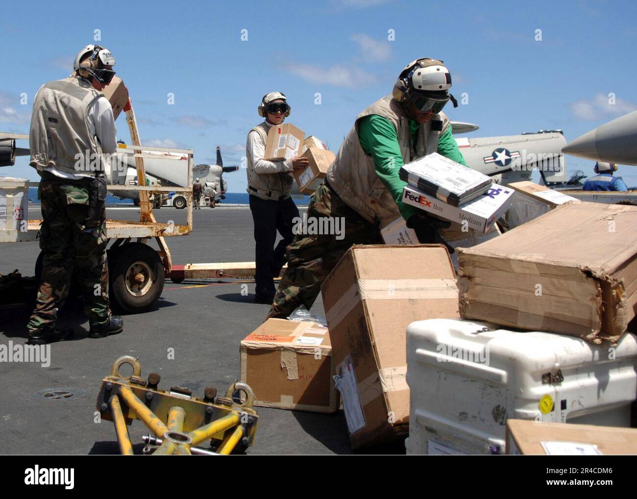 US Navy Flight deck personnel unload mail on the flight deck of the ...