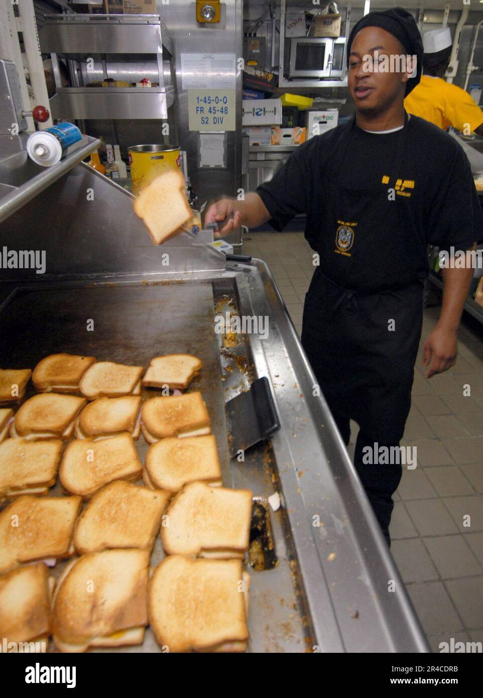 US Navy Culinary Specialist 3rd Class prepares grilled ham and cheese ...