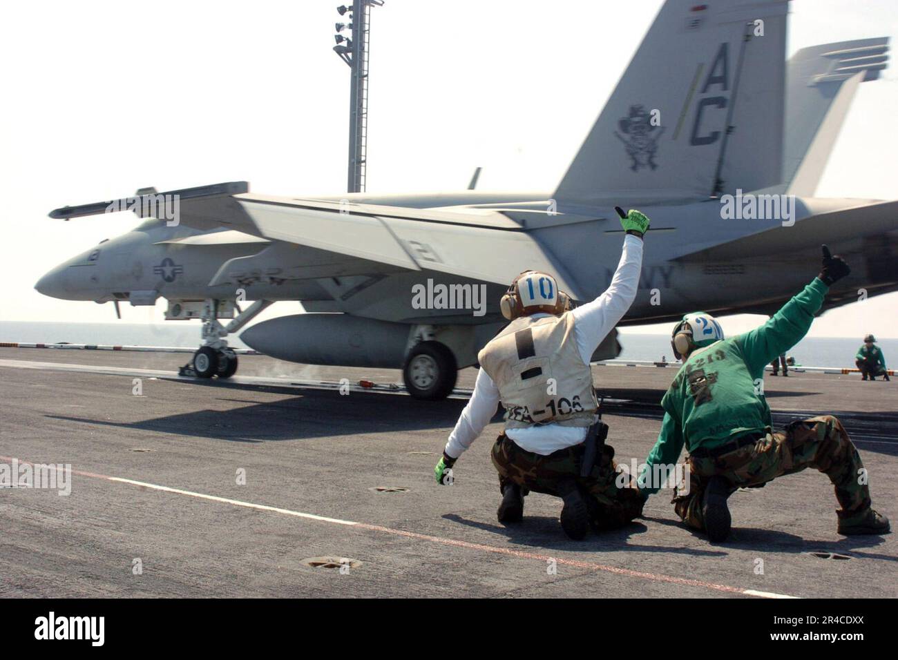 US Navy Flight deck crew members give the all clear signal for the ...