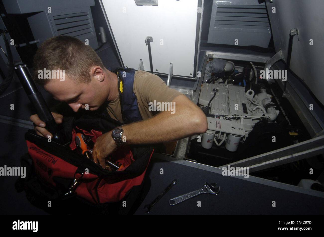 US Navy Engineman 2nd Class performs maintenance on a SeaArk rigid ...