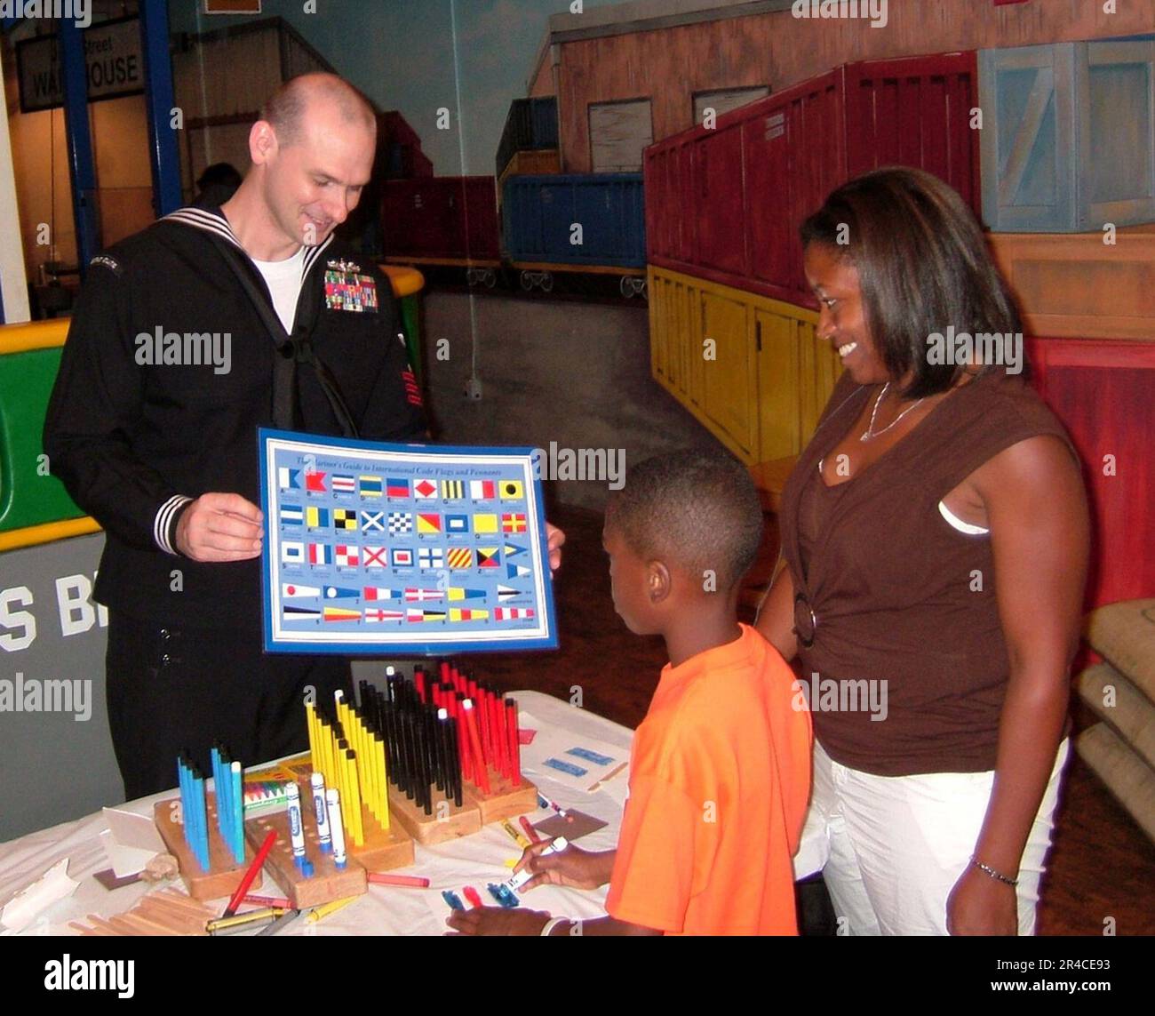 US Navy Personnel Specialist 1st Class explains signal flags to a young ...