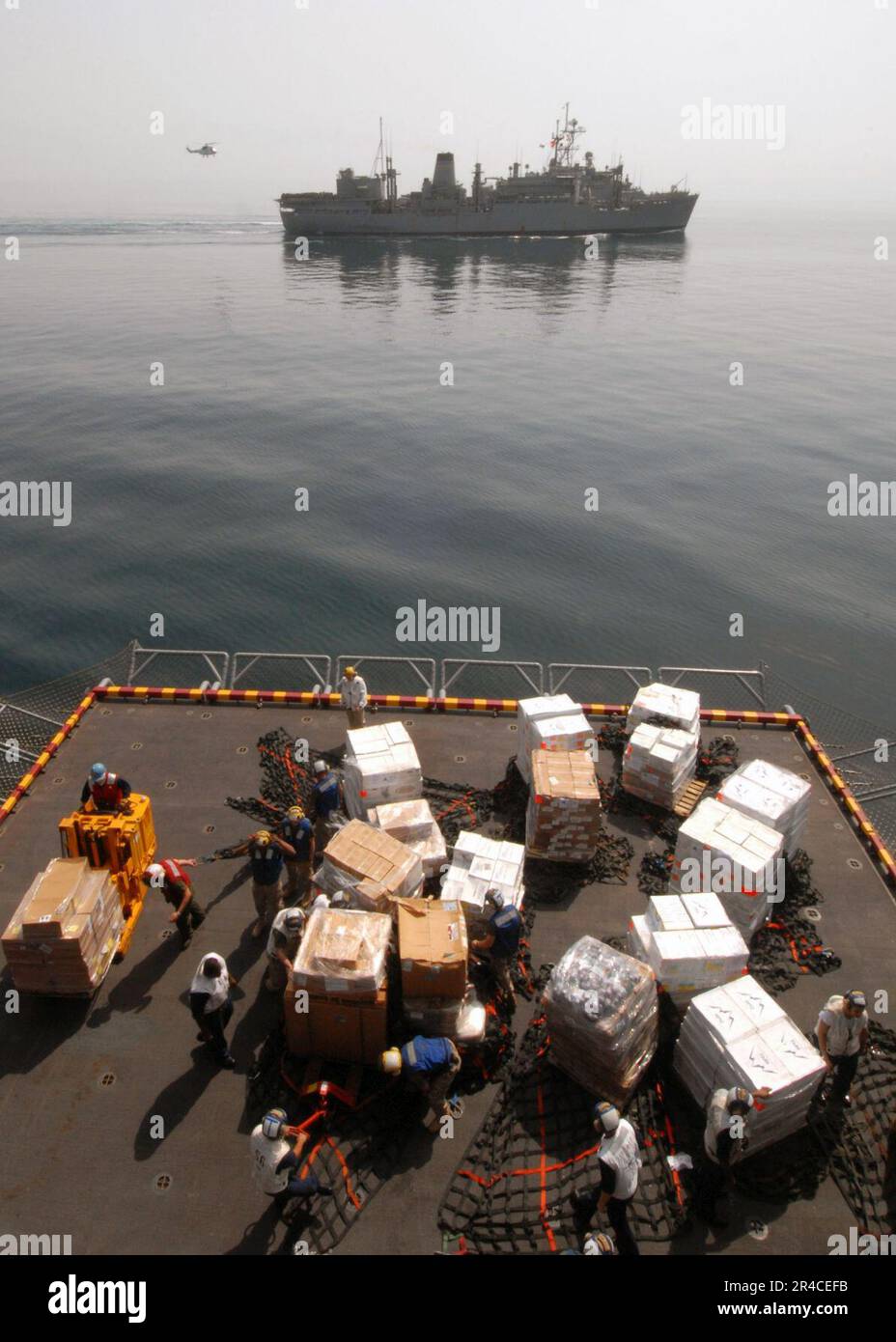 US Navy Sailors on the port side elevator move stores during a vertical ...
