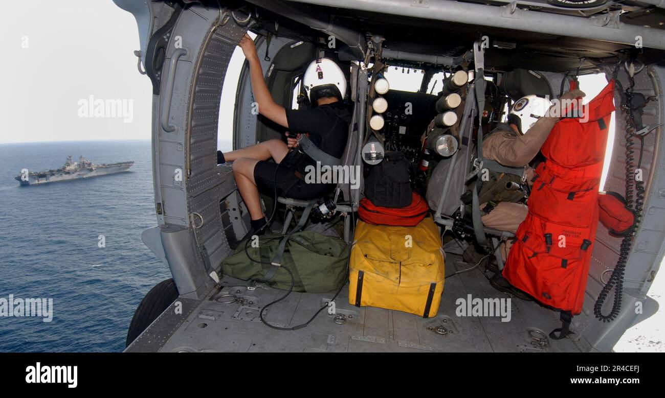 US Navy Air crew personnel observe flight operations a short distance ...