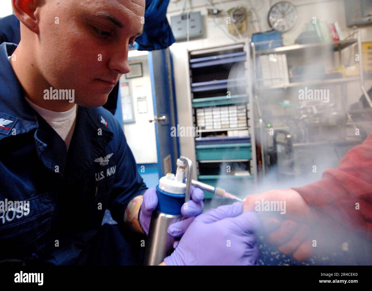 US Navy Corpsman 3rd Class removes a wart from a patient in the Medical ...