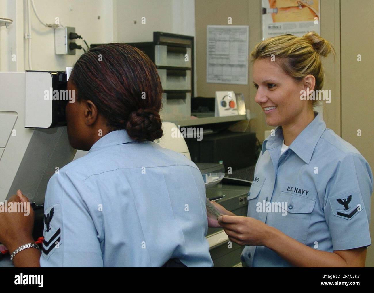 US Navy Hospital Corpsman 3rd Class performs a routine eye exam for a ...