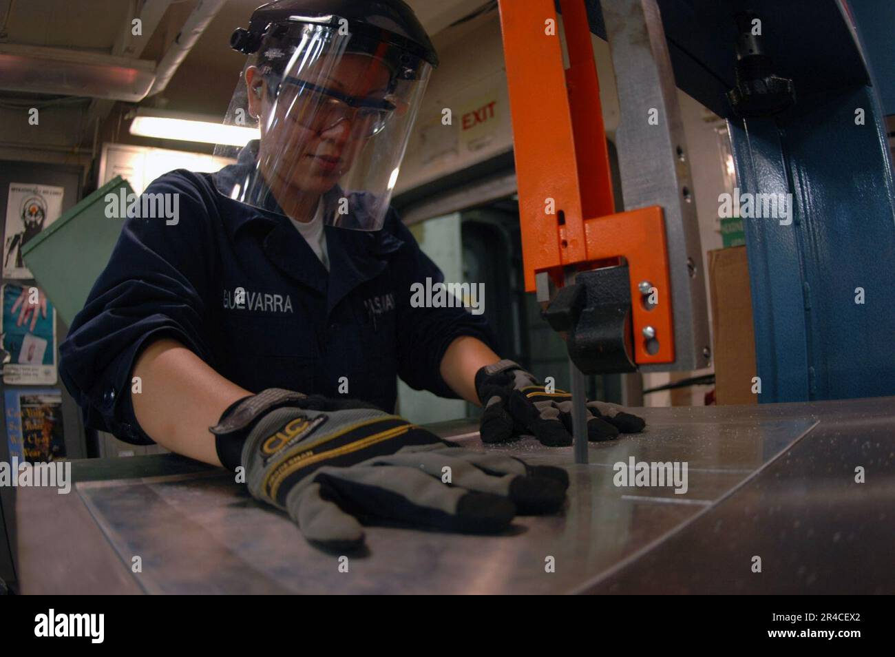 US Navy Aviation Structural Mechanic Airman uses a band saw to cut a ...