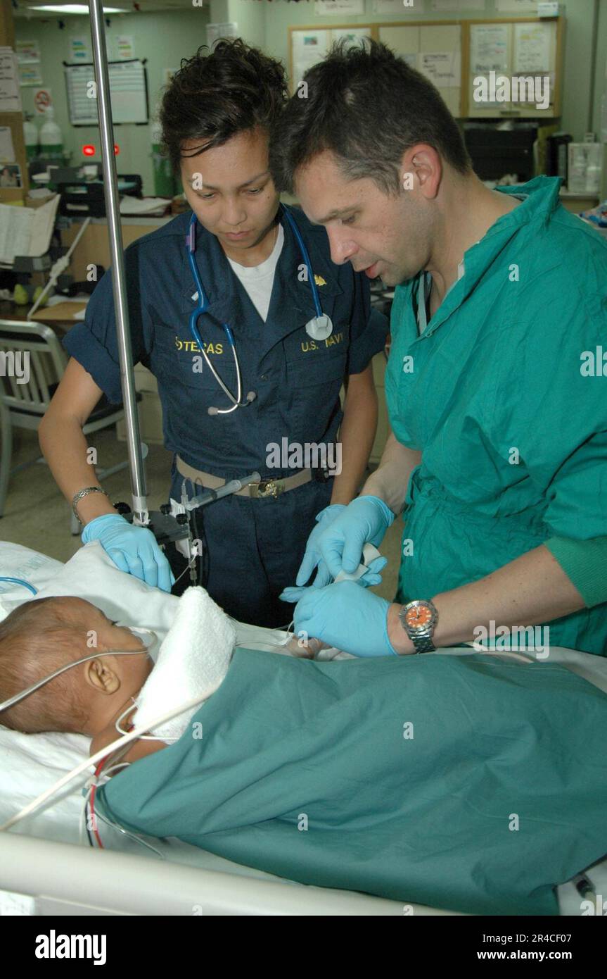 US Navy Navy Lt. j.g. observes as Cmdr. administers anesthetic to one ...