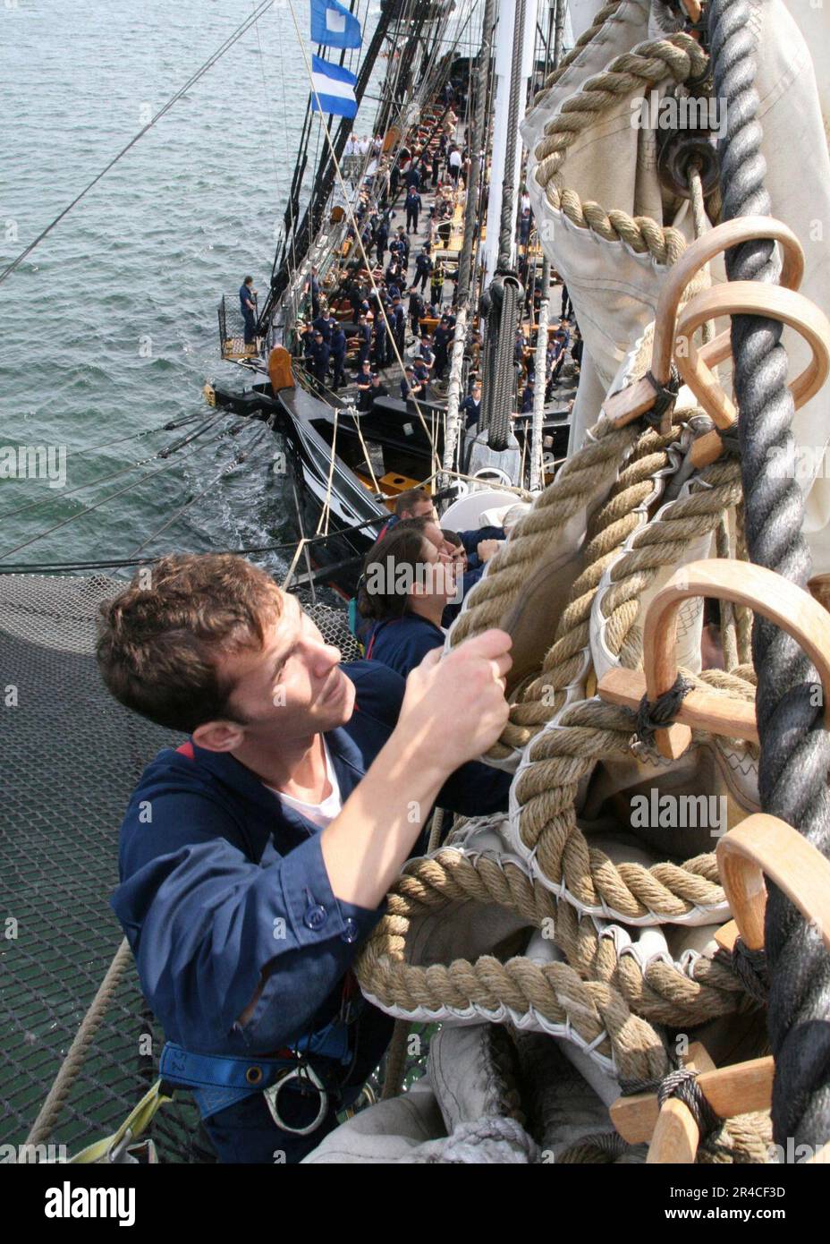 US Navy Seaman douses the flying jib on bowsprit aboard USS ...