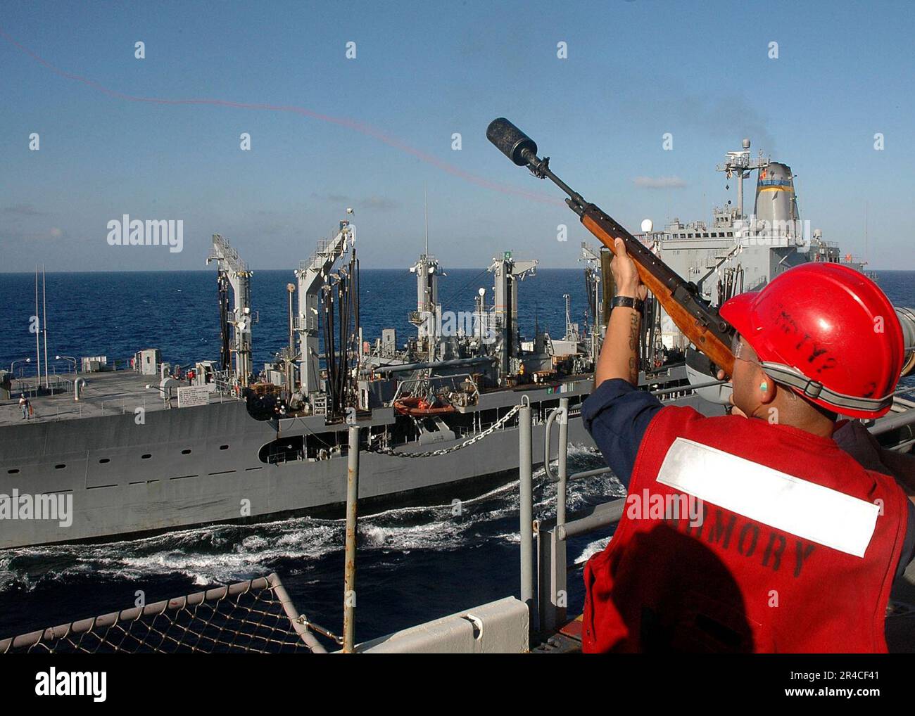 US Navy Gunner's Mate 3rd Class fires a line across to the Military ...