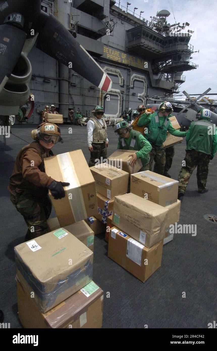US Navy Sailors stack mail on the flight deck aboard USS Kitty Hawk (CV ...