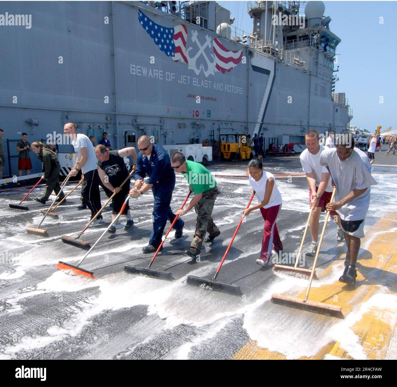 US Navy Sailors participate in a flight deck washdown aboard the ...