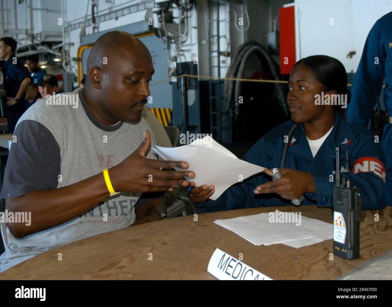 US Navy Hospital Corpsman 2nd Class helps Storekeeper 1st Class an ...