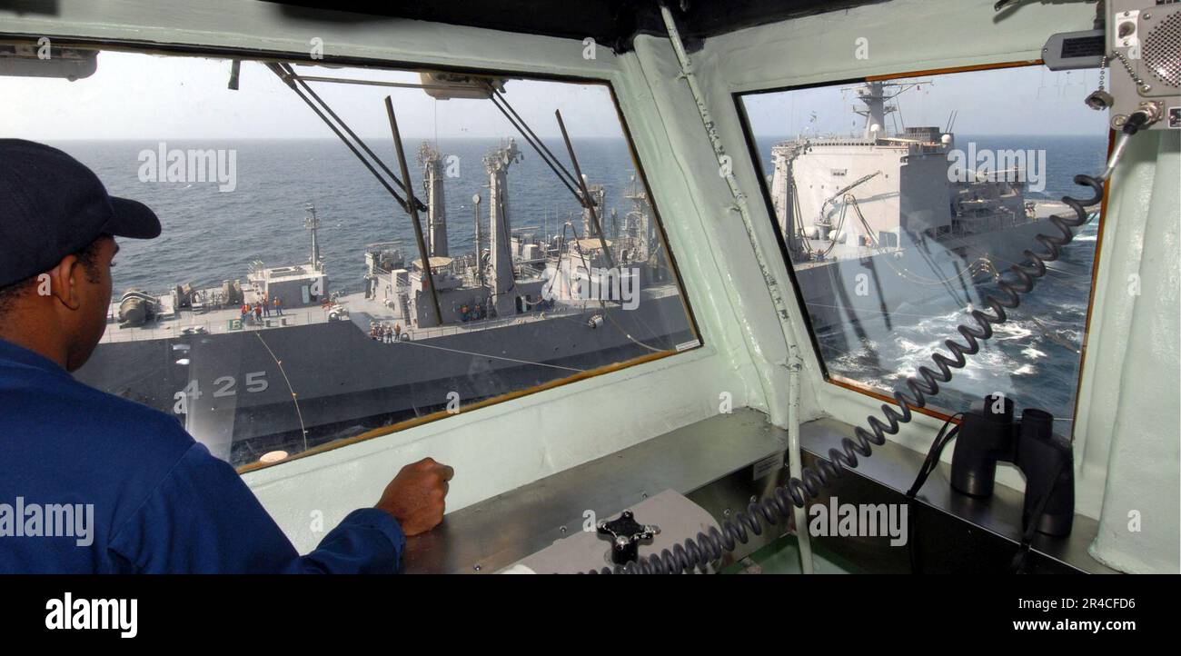 US Navy Ensign observes a replenishment at sea (RAS) between the Japanese supply ship Mashu (AOE ...