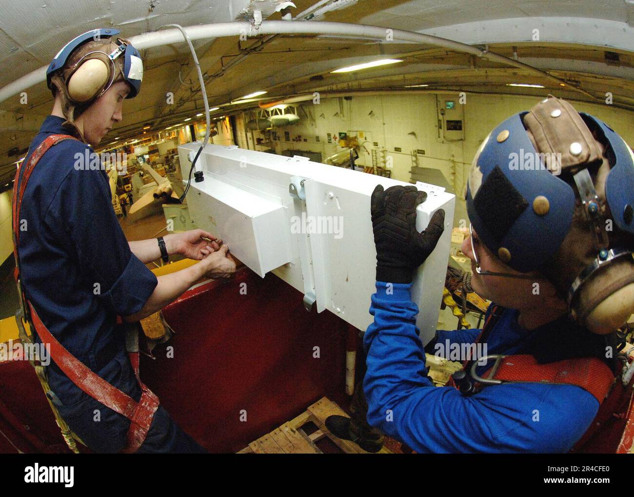 US Navy Electrician's Mate 2nd Class left, and Airman replace a light ...