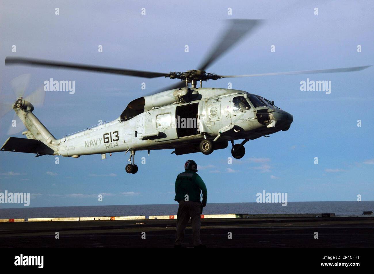 US Navy A Sailor assigned to Helicopter Antisubmarine Squadron Four (HS-14) observes an SH-60F ...