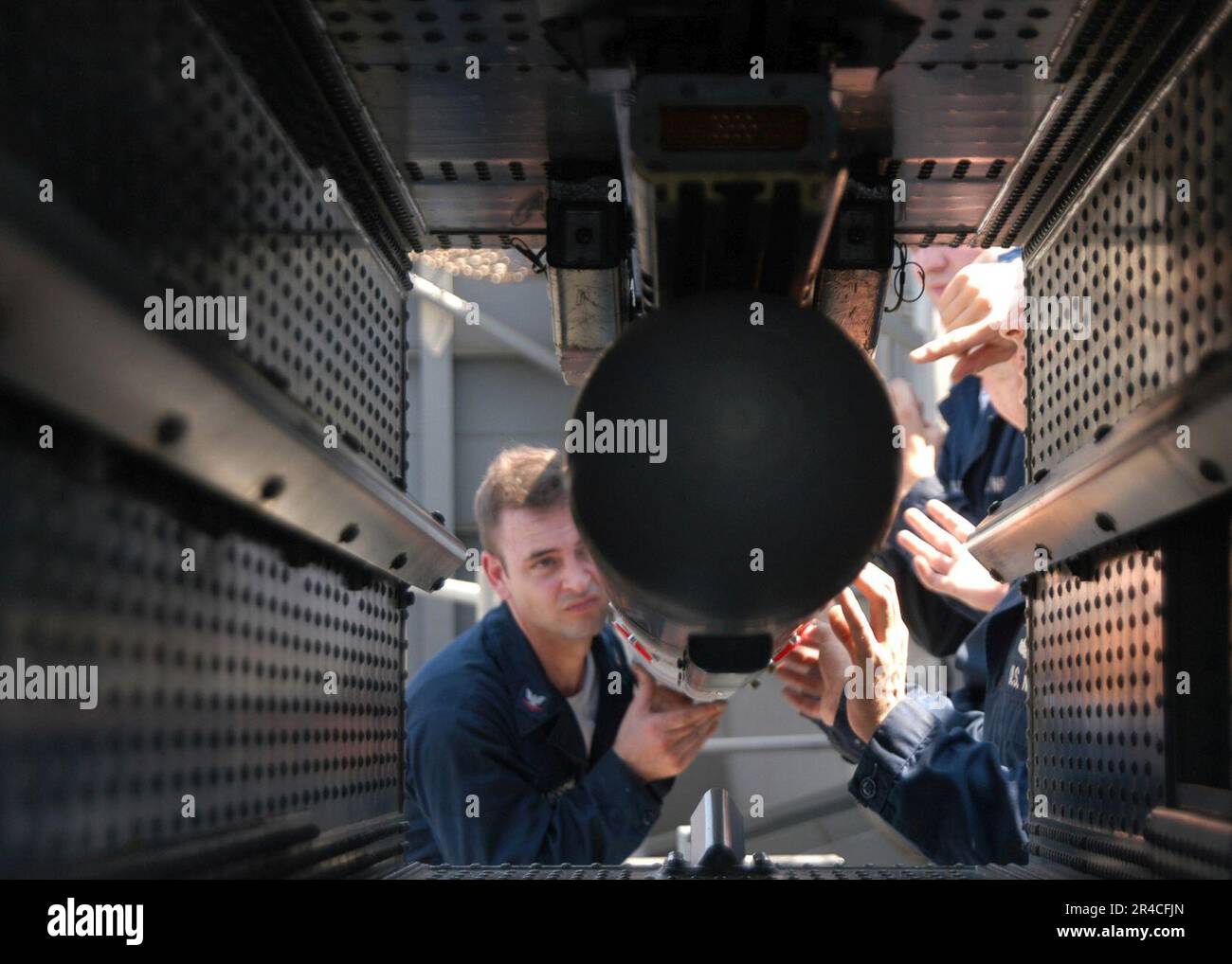 US Navy Fire Controlman 3rd Class loads a RIM-7 guided missile into the ...