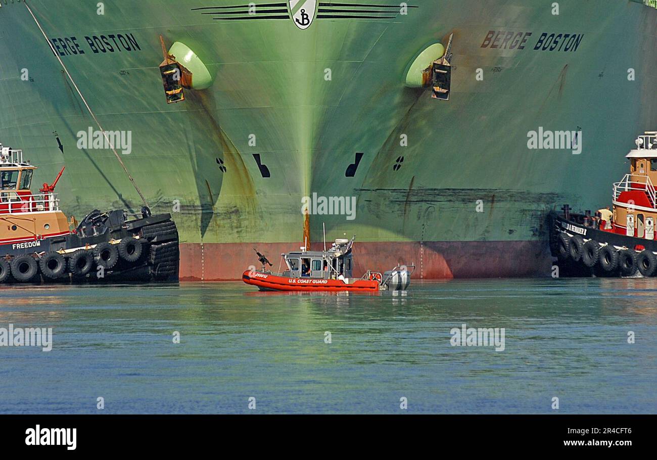 US Navy A Coast Guard 25-foot response boat is flanked by two tugs as ...