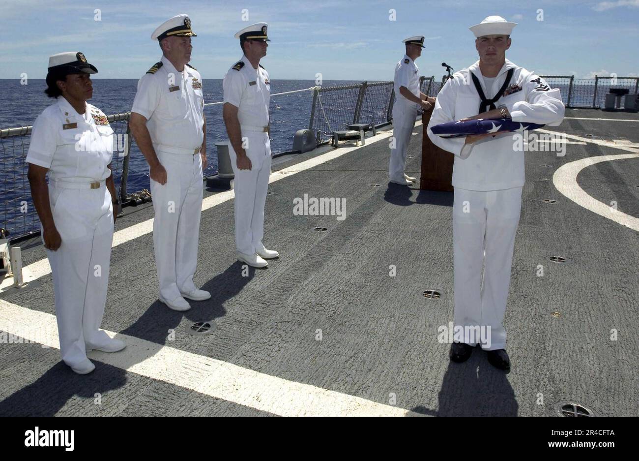 US Navy Gunner's Mate 2nd Class presents an American Flag to USS Hopper ...