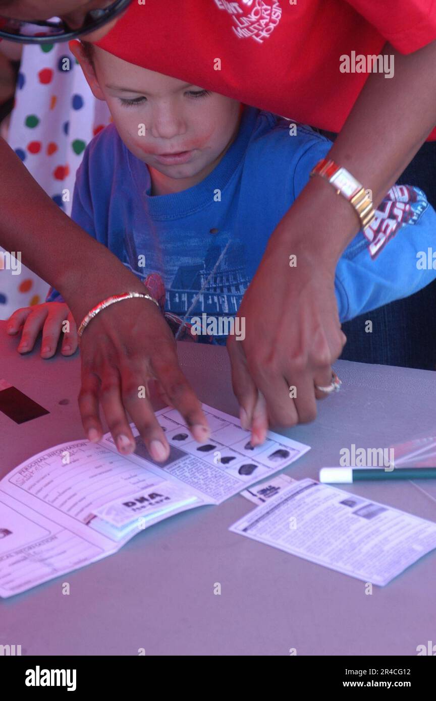 US Navy A young boy has his fingerprints taken for a child ...