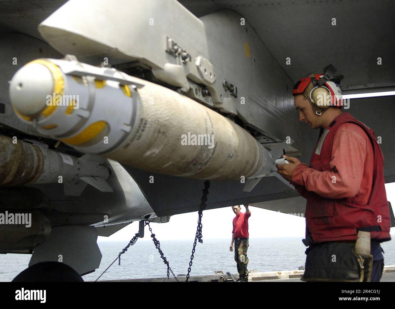 US Navy Aviation Ordnanceman 2nd Class verifies component serial ...