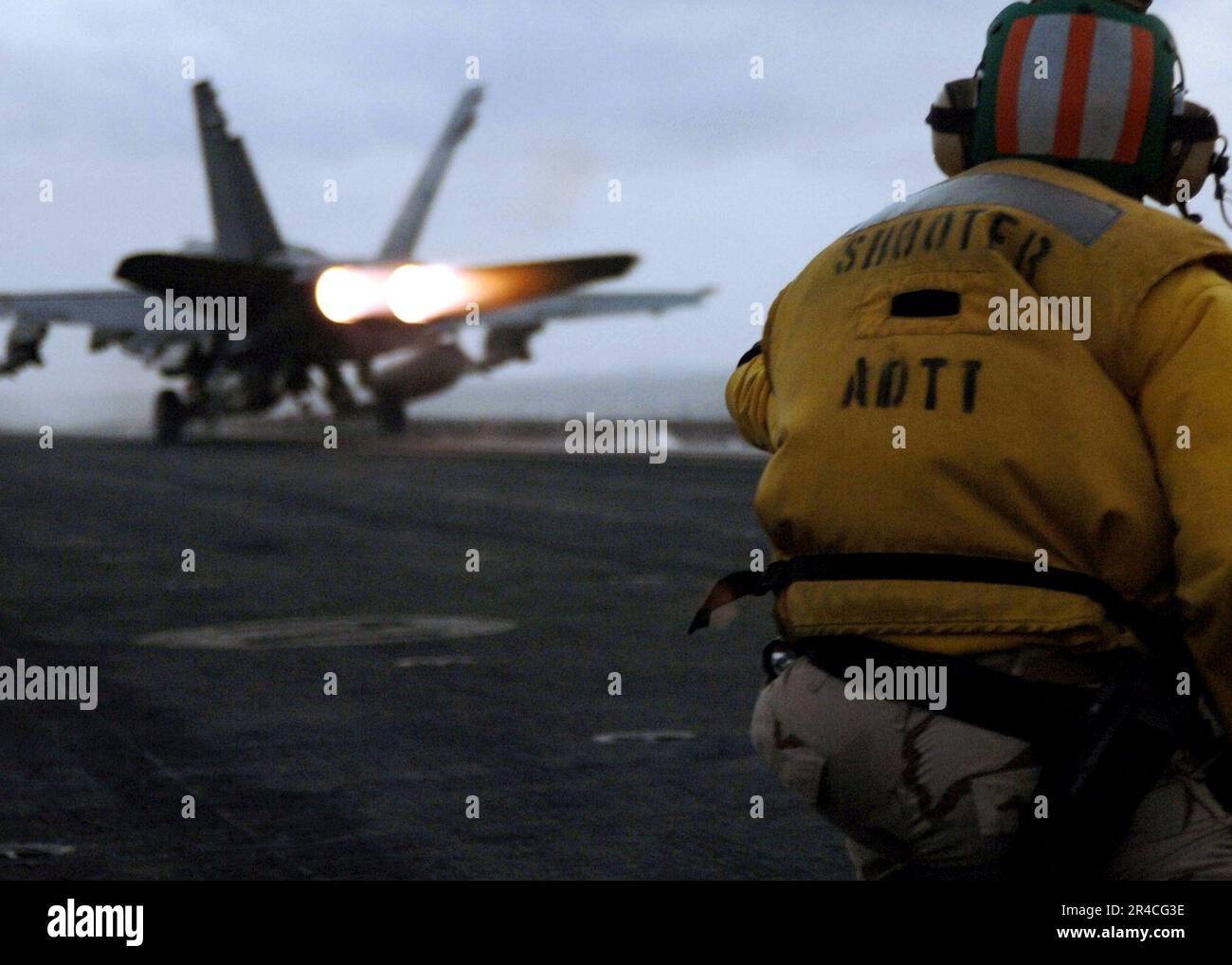 US Navy Catapault Officer, Lt. Cmdr. signals to launch an F-A-18 Hornet ...