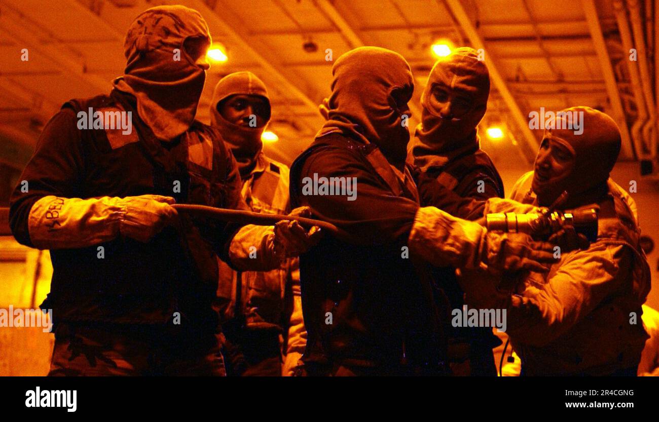 US Navy Sailors conduct damage control training in the hangar bay ...