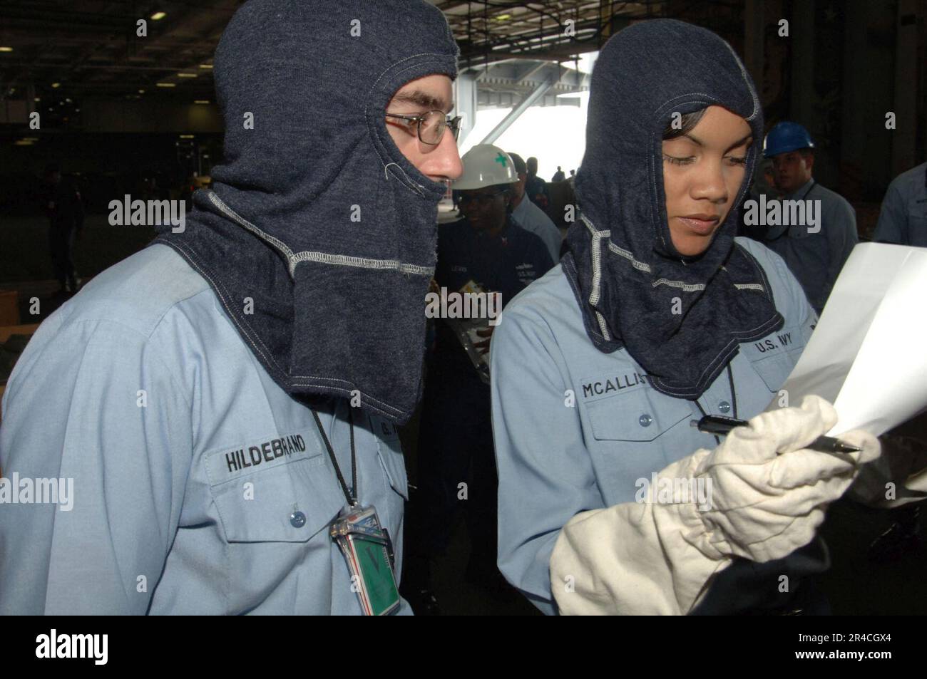 US Navy Yeoman 2nd Class looks over the muster sheet during a general ...