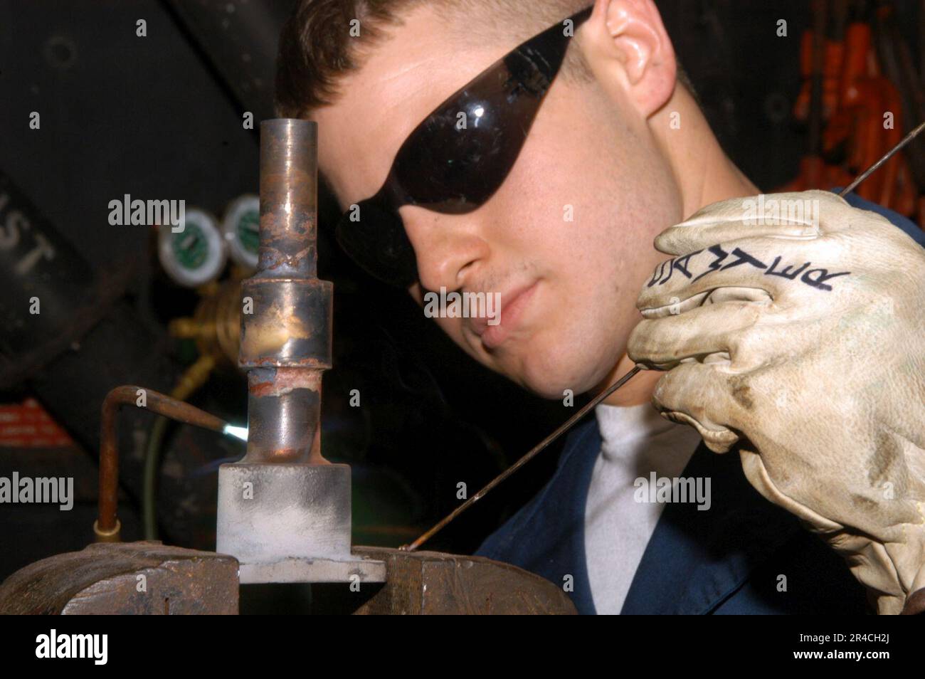 US Navy Hull Maintenance Technician Fireman brazes a heat exchanger for ...
