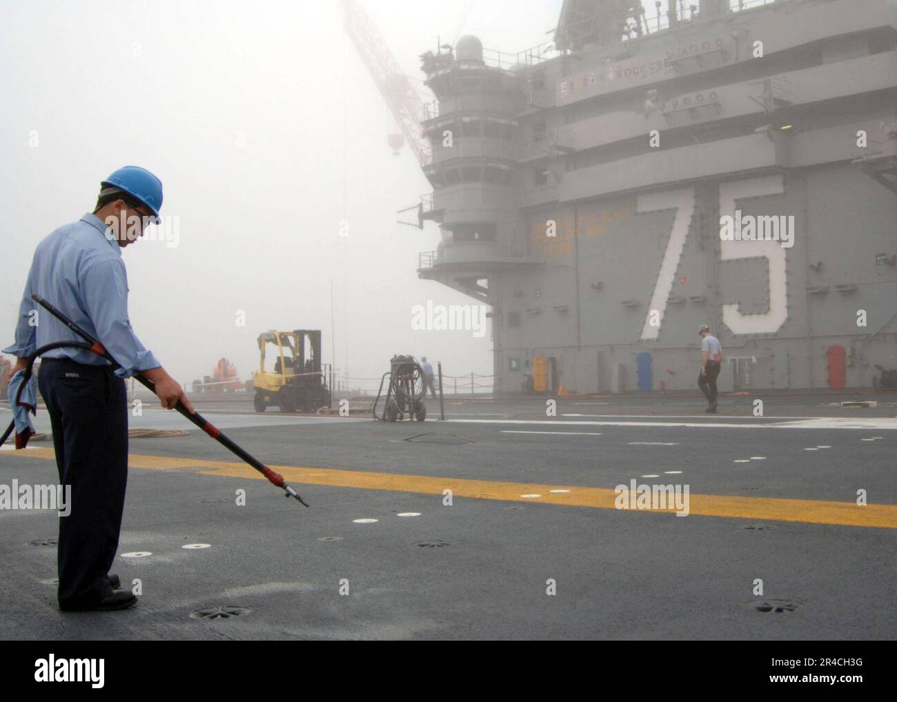 US Navy Aviation Boatswain's Mate (Handler) Airman uses a low-pressure ...