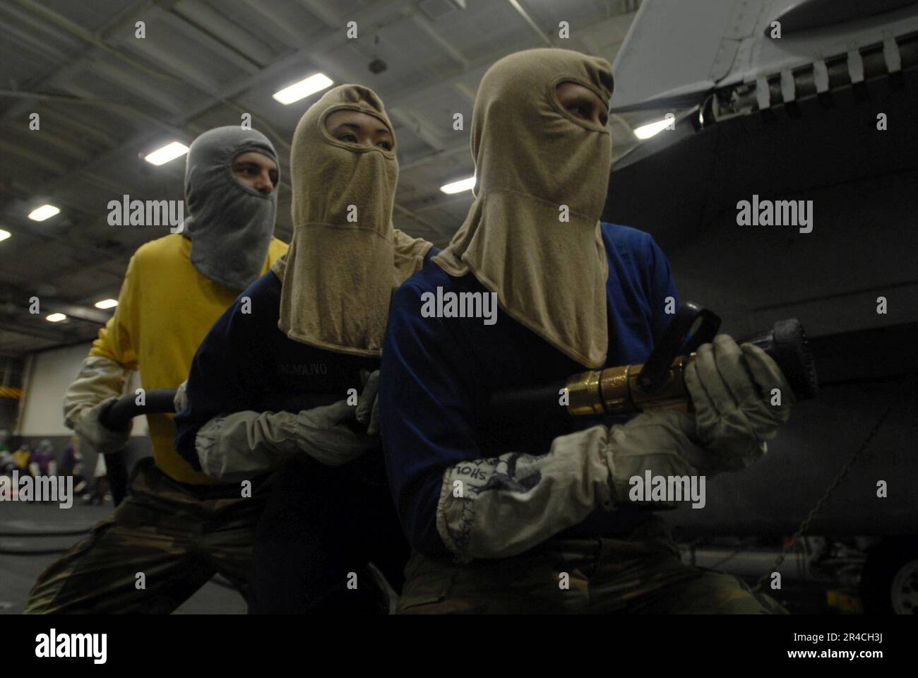 US Navy Crew members fight a simulated class alpha fire during a ...