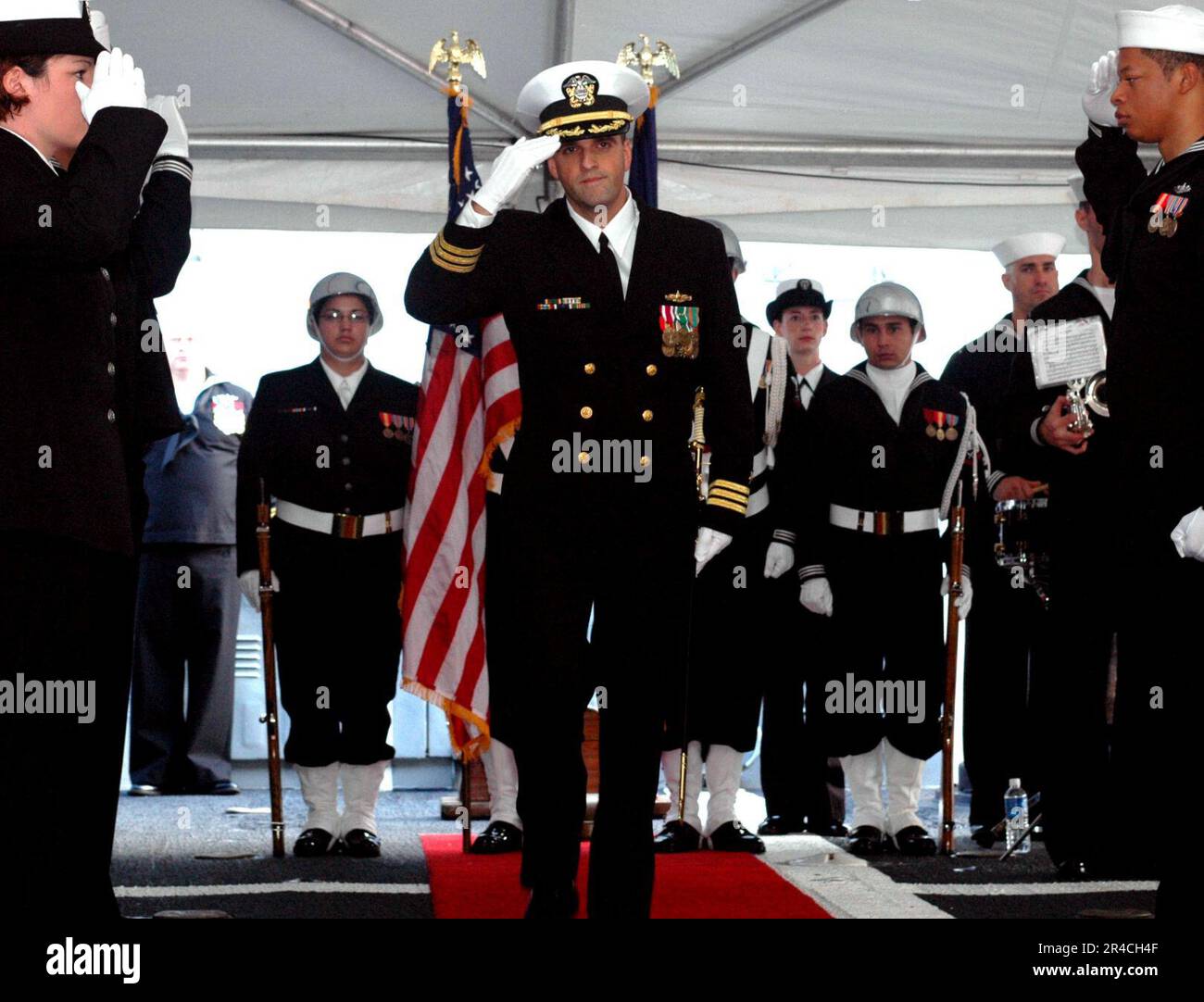 US Navy Cmdr. salutes the side boys during the change of command ...