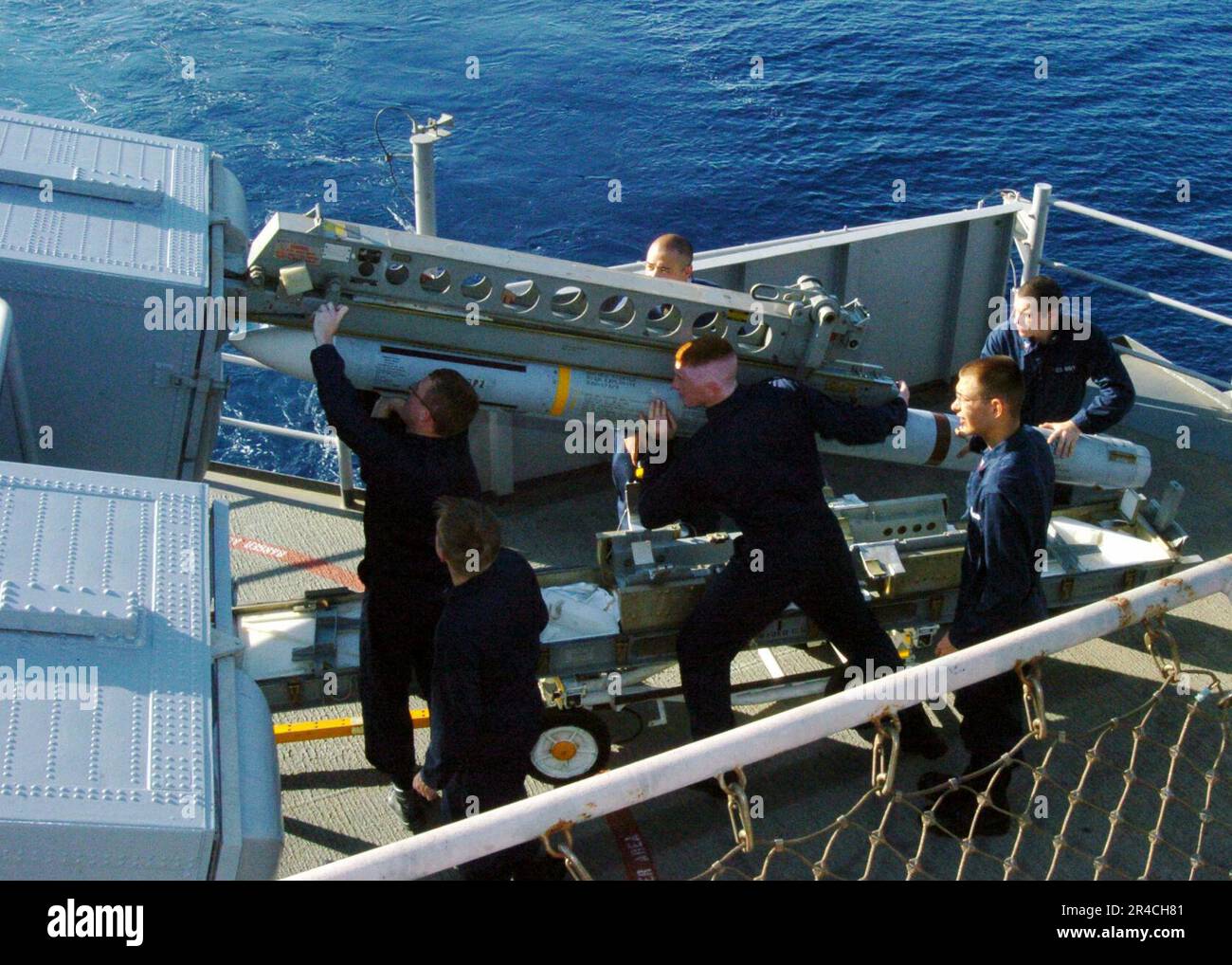 US Navy Fire Controlmen lock a RIM-7 missile into the missile loader ...