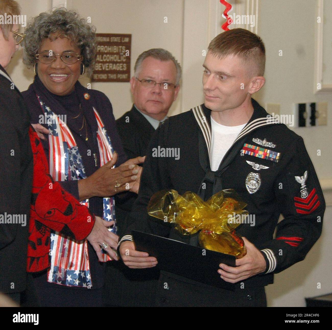 US Navy Master-At-Arms 1st Class receives a token of appreciation, from ...