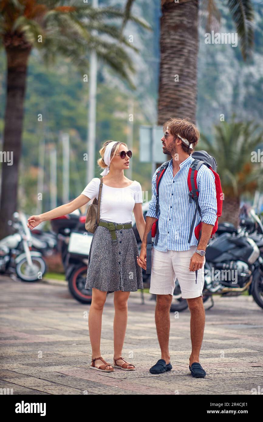 Couple looking for direction in summer city on holiday, holding hands ...