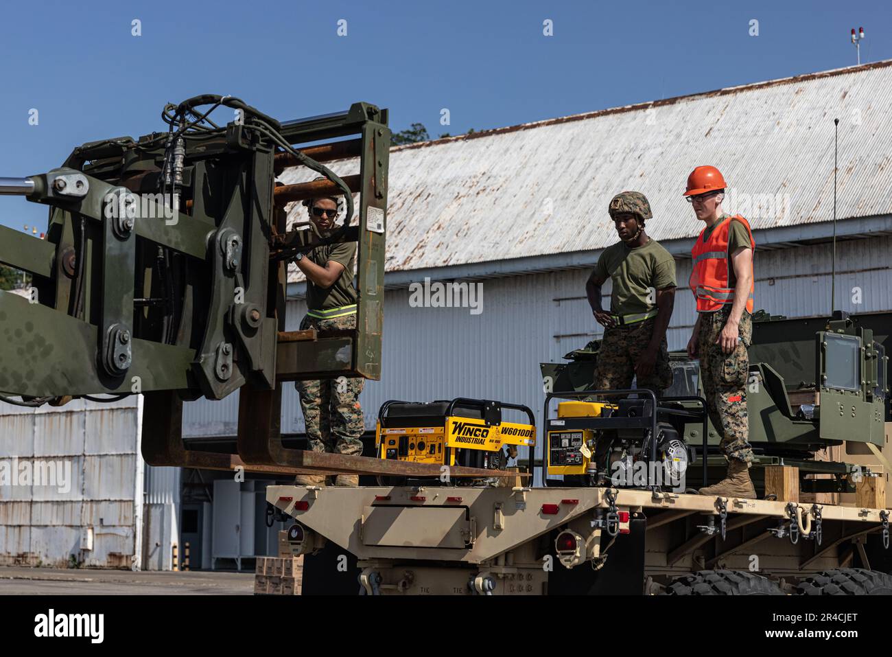 U.S. Marines with 3rd Landing Support Battalion guide a forklift at the ...