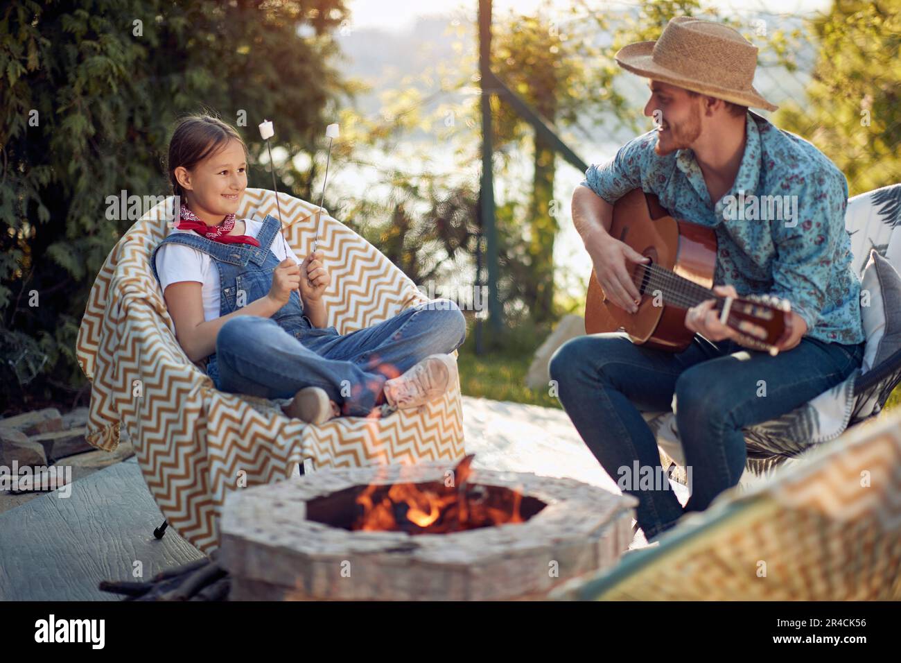 Seated by a crackling fire, the father strums a classical guitar ...